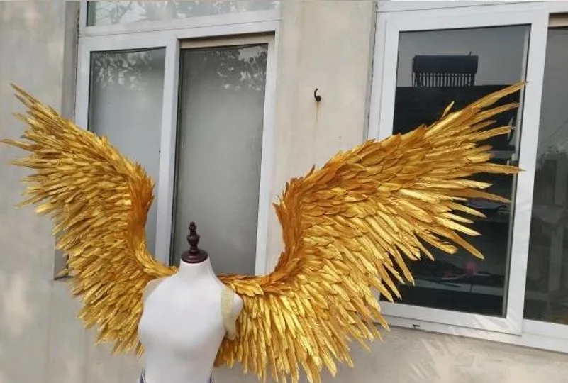 Elegantes alas de plumas grandes, blancas, negras y doradas, modelo de ...