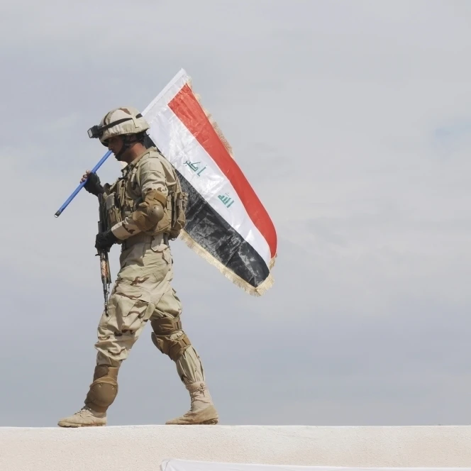 An Iraqi soldier carries the Iraqi flag Poster Print (34 x 22)|Plaques ...