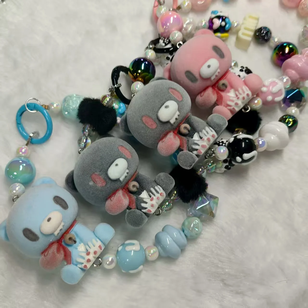 These cute keychains have bear charms in blue, gray and pink with ...