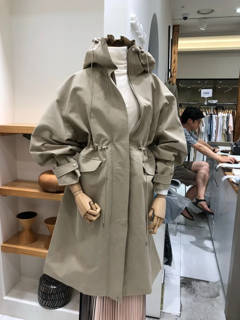 한국 동대문 2023 여름 새로운 한국 스타일 드로 스트링 허리 포옹 슬리밍 중간 길이 후드 트렌치 코트 겉옷 여성 패션